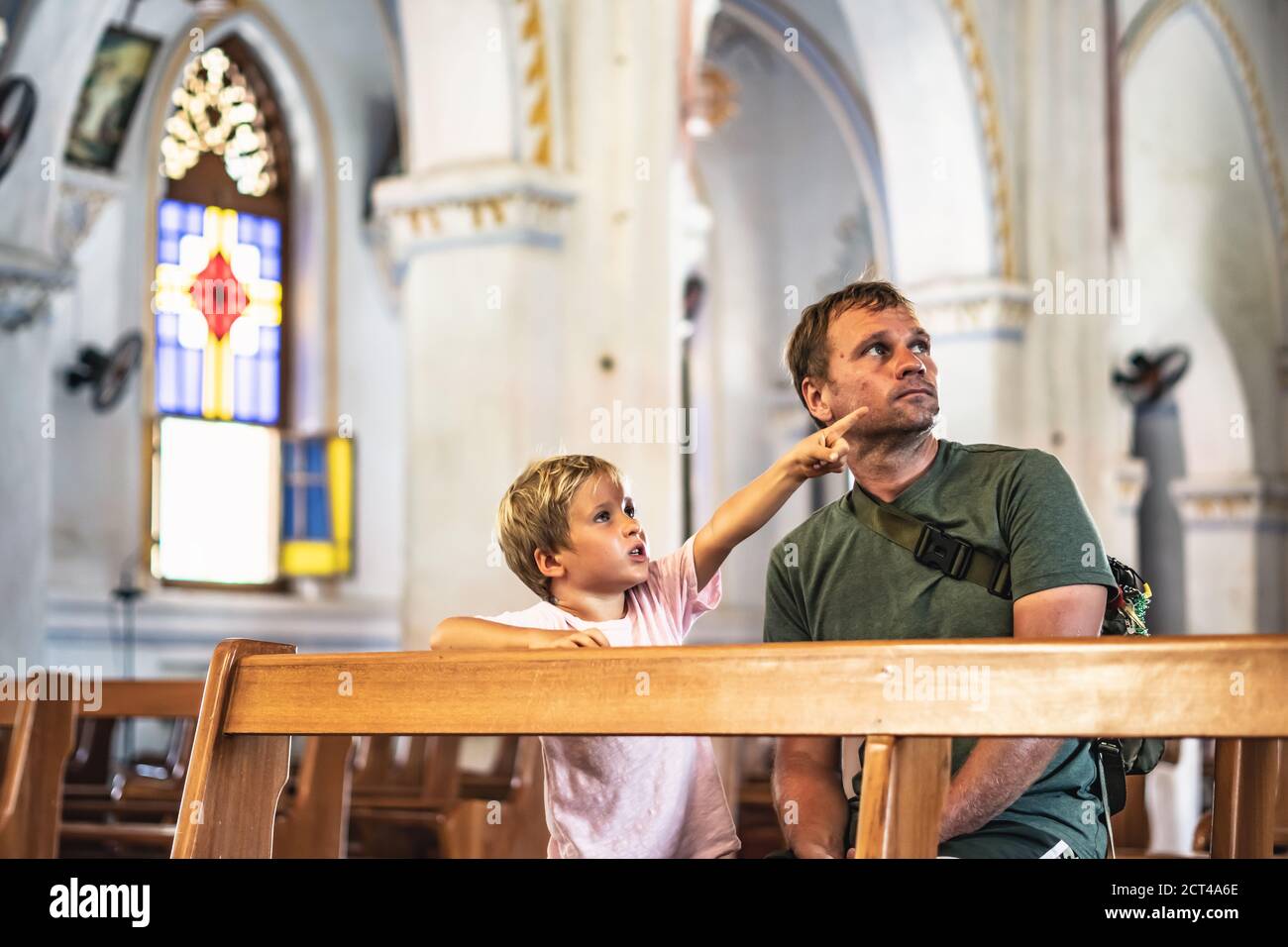 Christian dad tells his son Bible stories about Jesus sitting in kirk ...