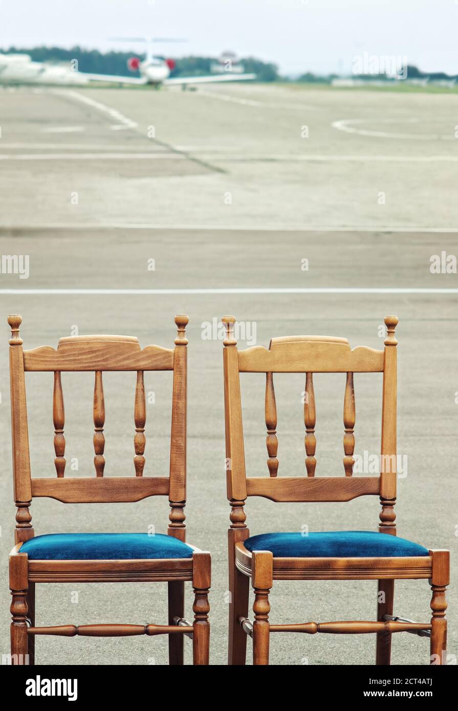 Two wooden chairs on airfield for VIP with blurred private jet in ...