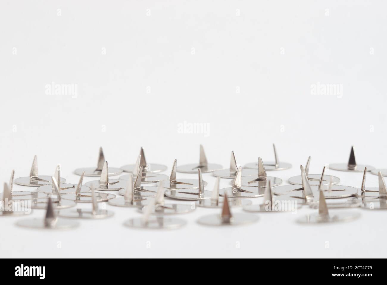 Bunch of old-fashioned metal drawing pins turned upside down with ...