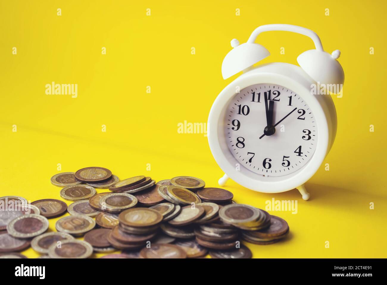 Alarm clock and money coin on yellow background,finance concept ...
