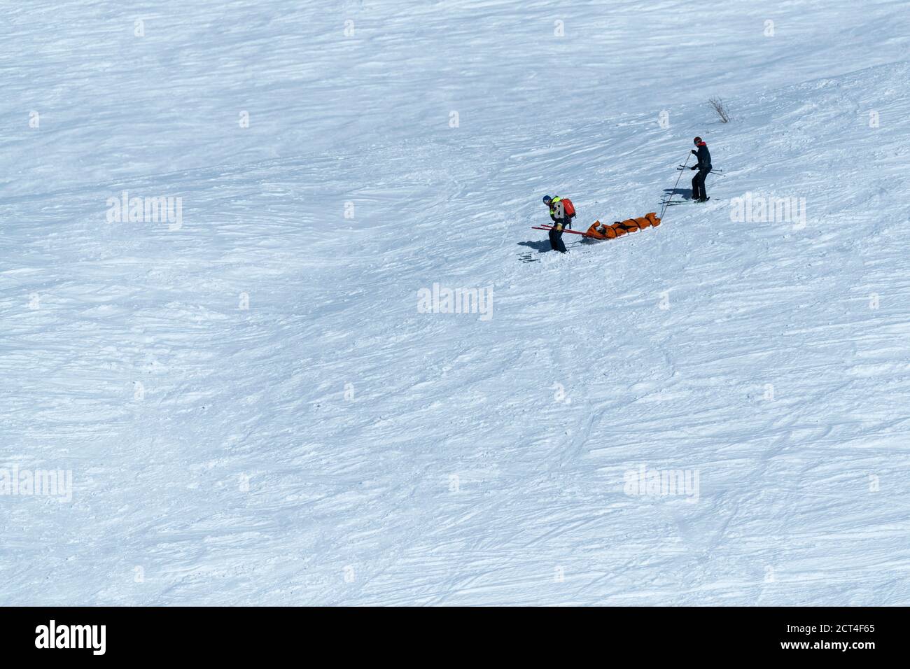 Mountain rescue team rescuing an injured skier in a stretcher after ...