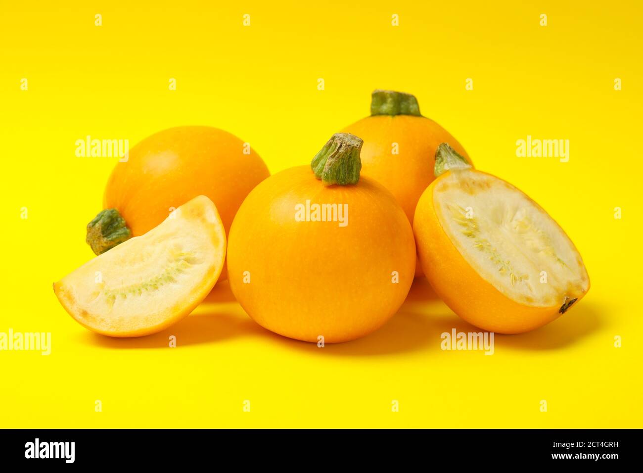 Bunch of round zucchini on yellow background Stock Photo - Alamy