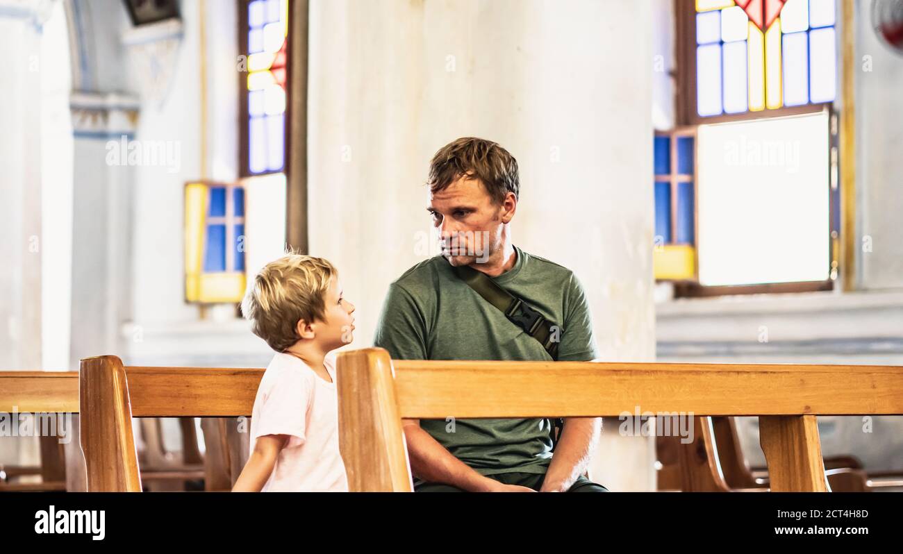 Christian dad tells his son Bible stories about Jesus sitting in kirk ...