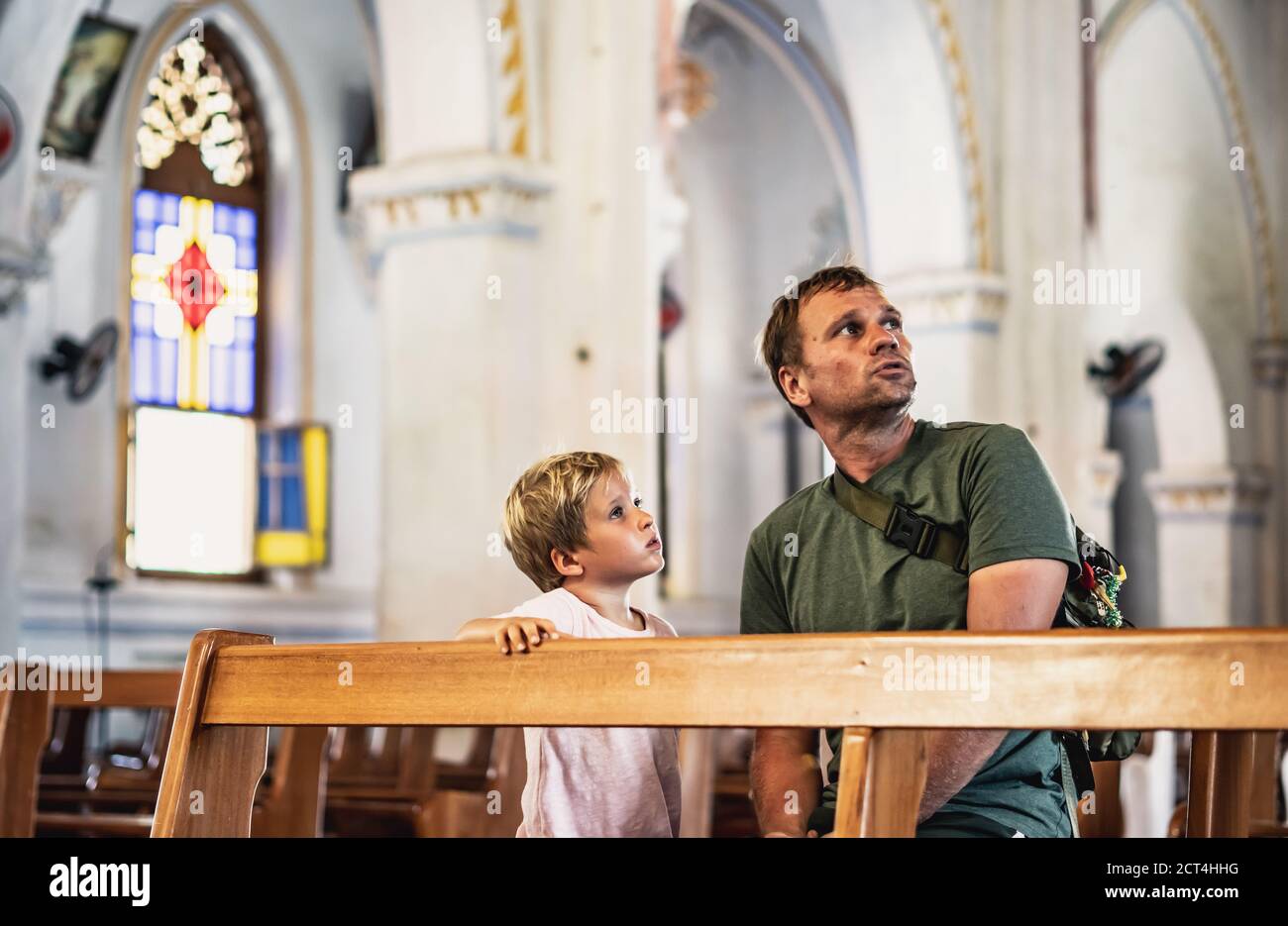 Christian dad tells his son Bible stories about Jesus sitting in kirk ...