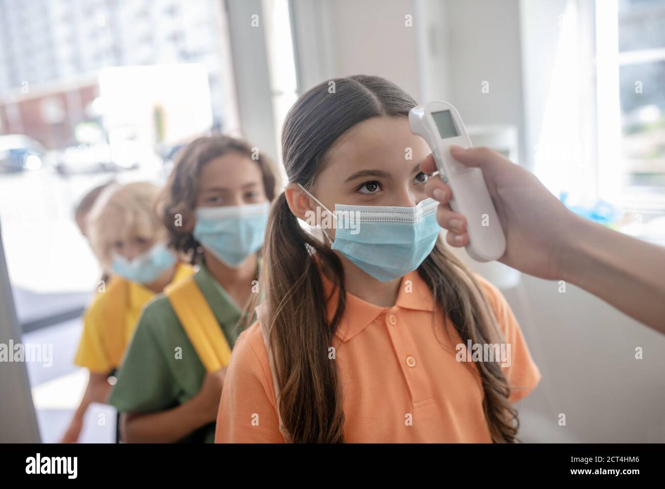 Children passing temperature control while entering the school Stock ...