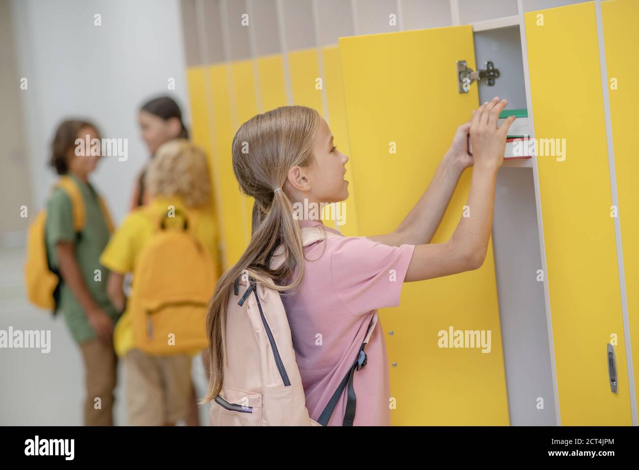 Girl opening her locker hi-res stock photography and images - Alamy