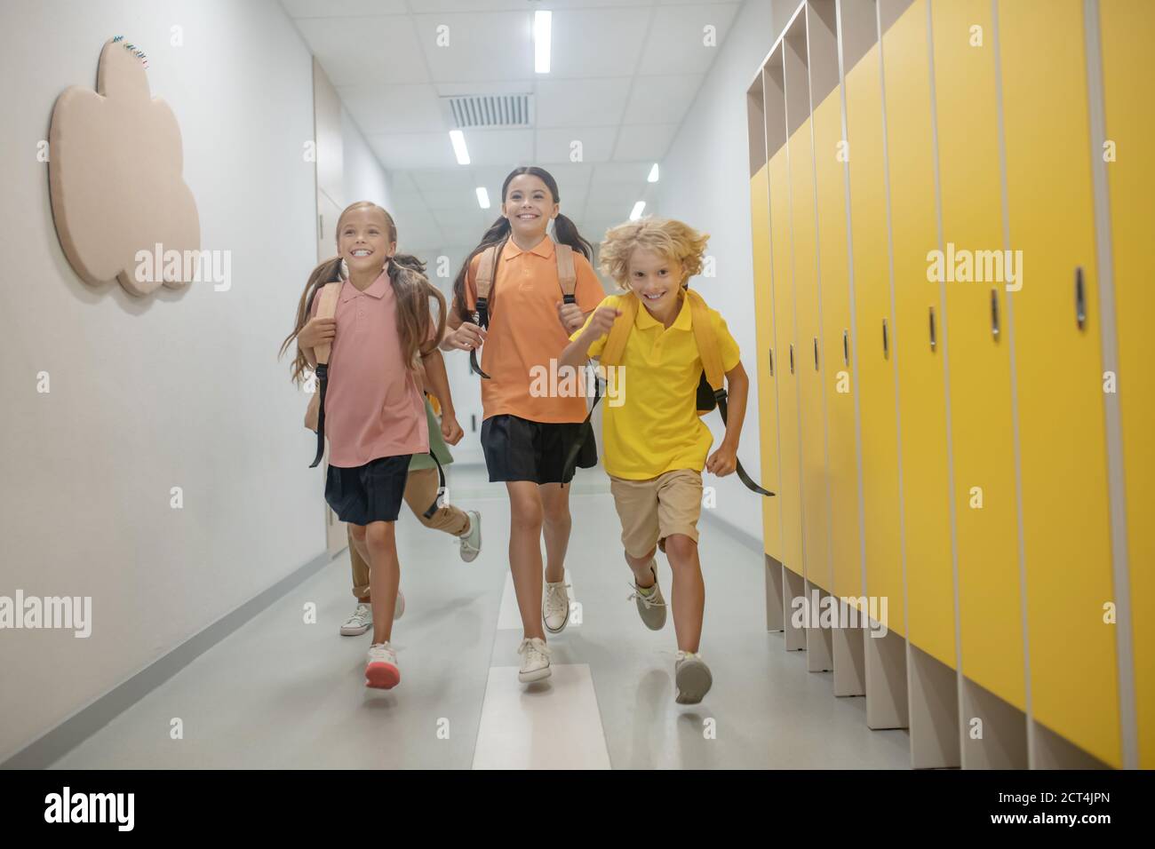 Schoolchildren running in the school corridor after lessons Stock Photo ...