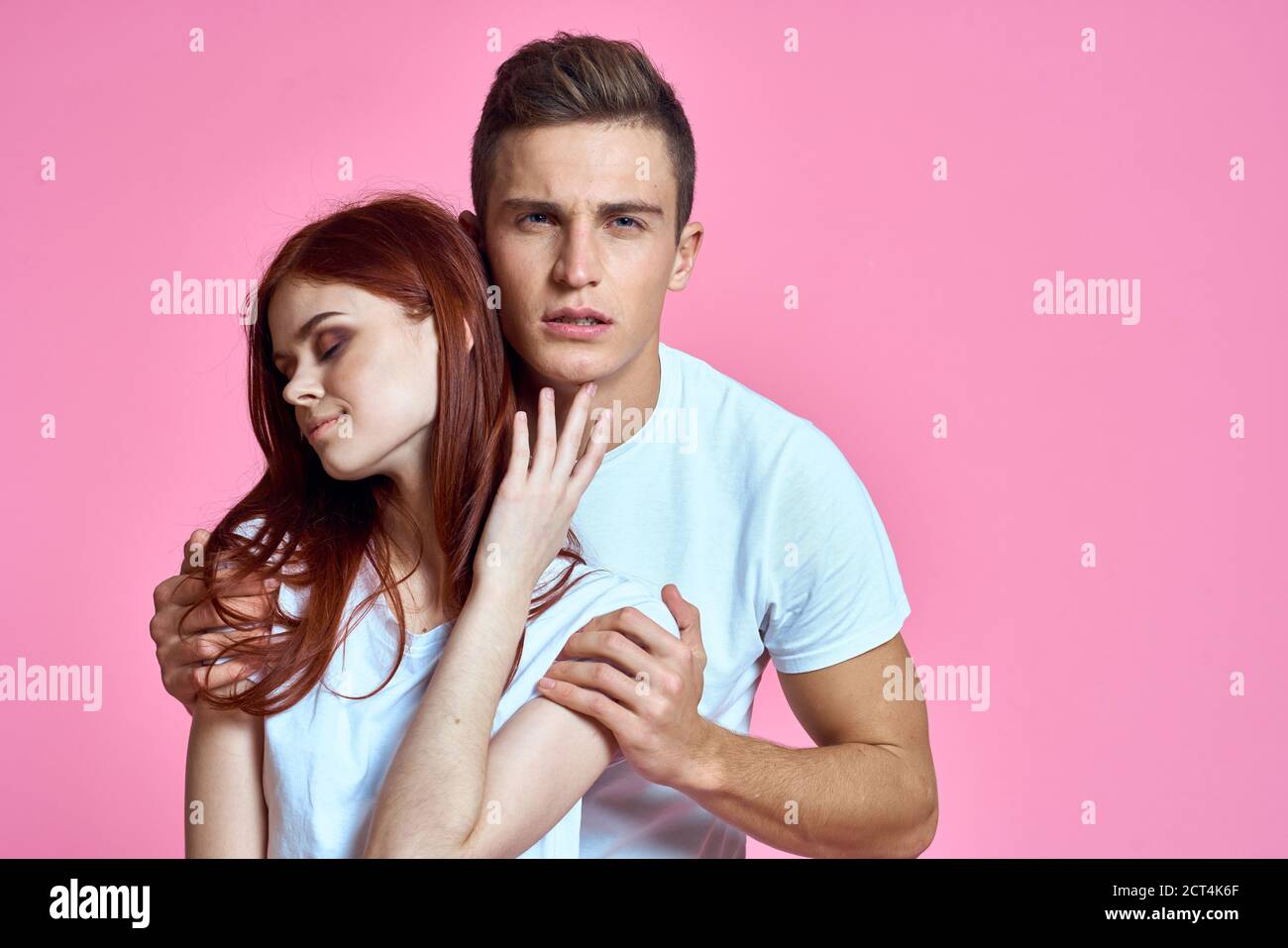 enamored man and woman hugging each other on a pink background cropped ...