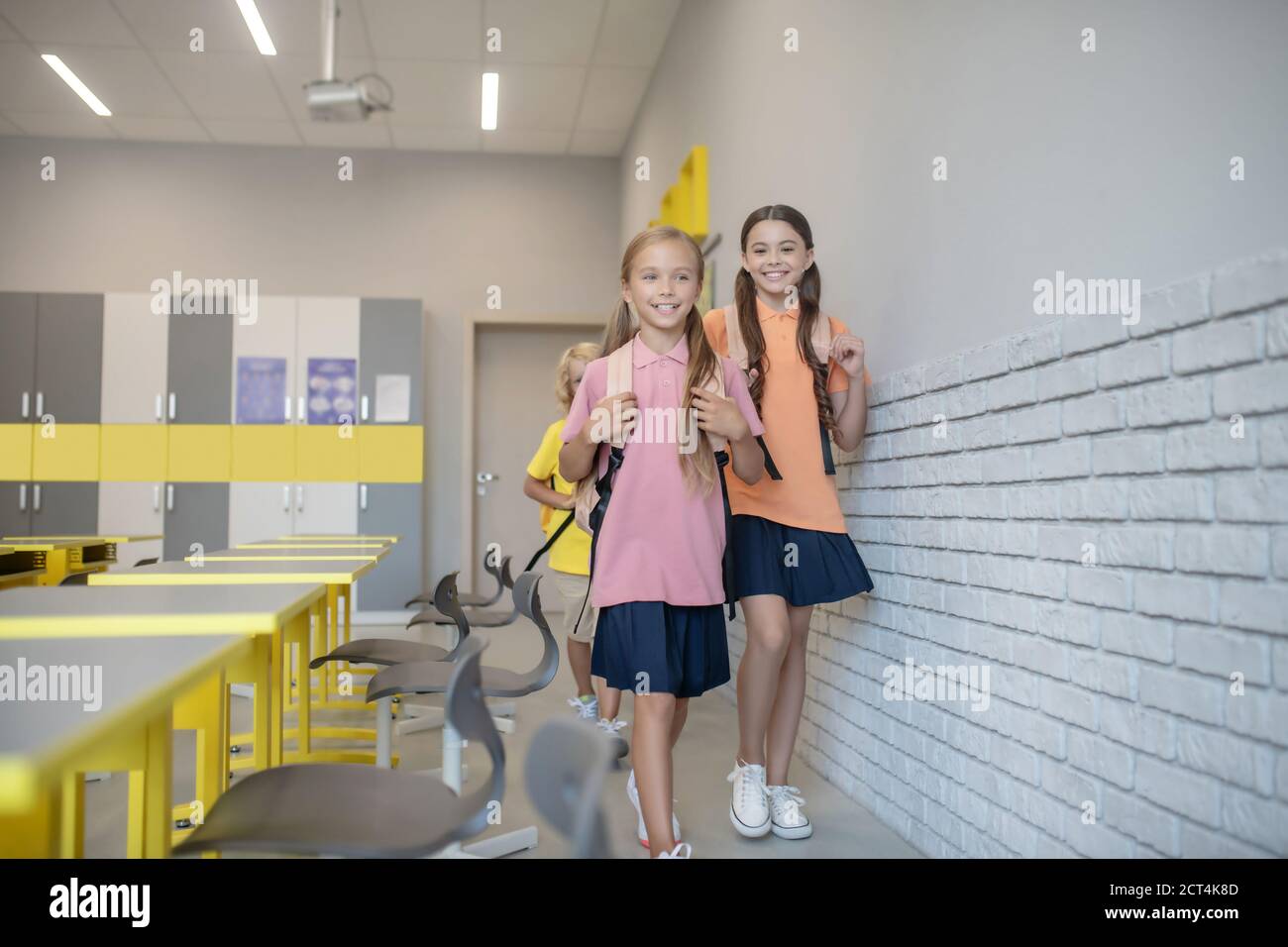 Two girls entering the classroom before the lesson Stock Photo - Alamy