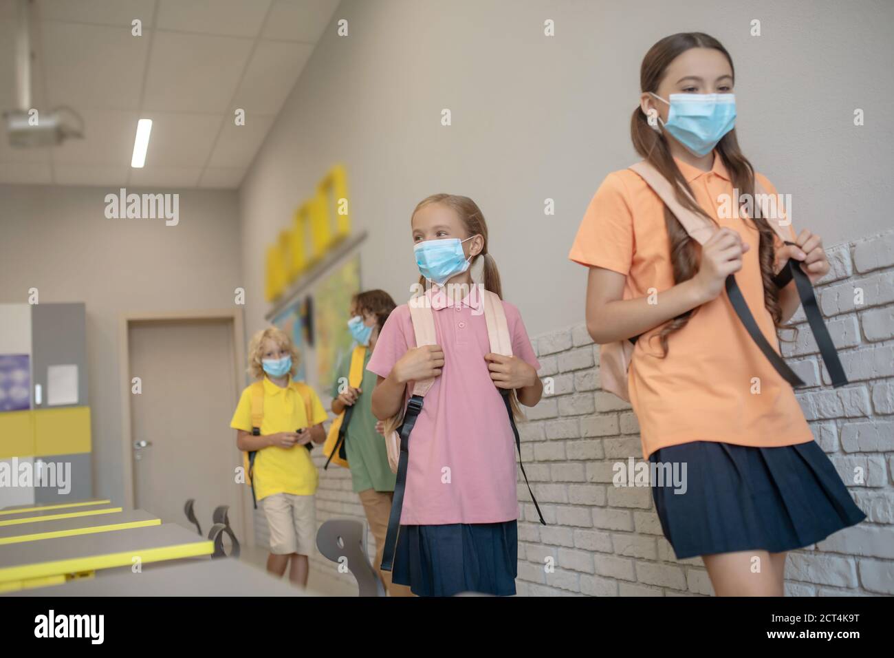 Children in masks entering the classroom before the lesson Stock Photo ...