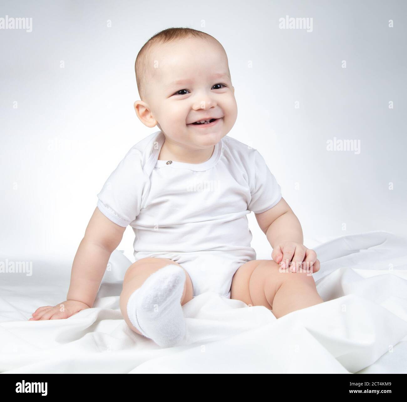 Photo of sitting eleven-month-old baby on a white background Stock ...