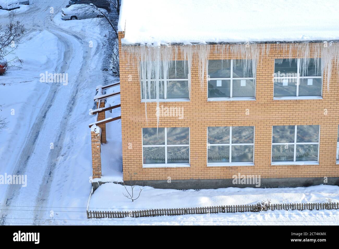 Top view of an icy building with large icicles on the background of ...