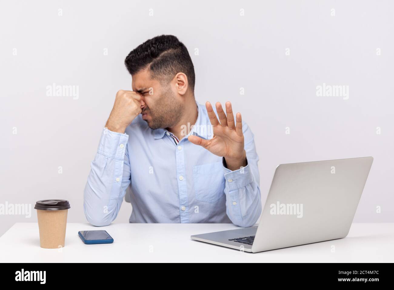 Displeased male employee confused by bad smell in office workplace ...