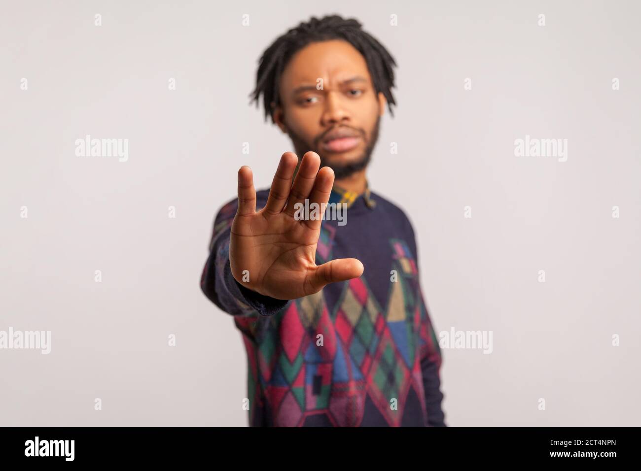 Worried african man with dreadlocks showing stop gesture with palm of ...