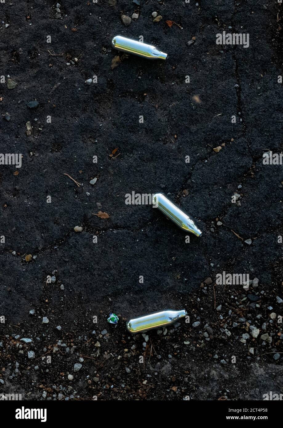 Nitrous oxide "laughing gas" capsules containers silver bottles left ...