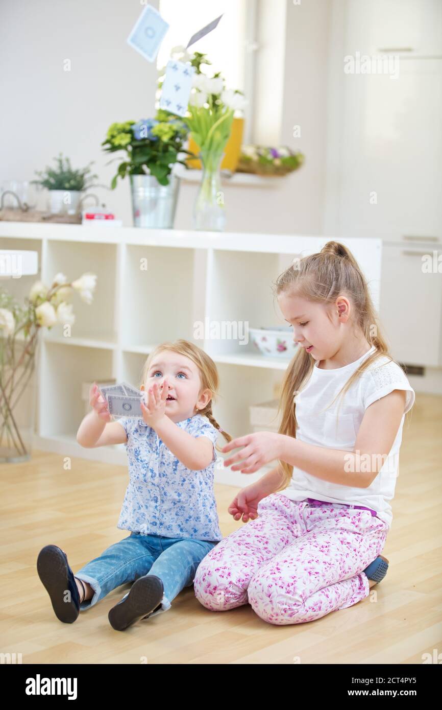 Two children throw cards high in the air while playing Stock Photo - Alamy