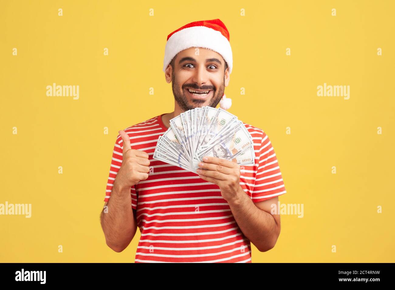Happy satisfied bearded man in red t-shirt and santa claus hat showing ...