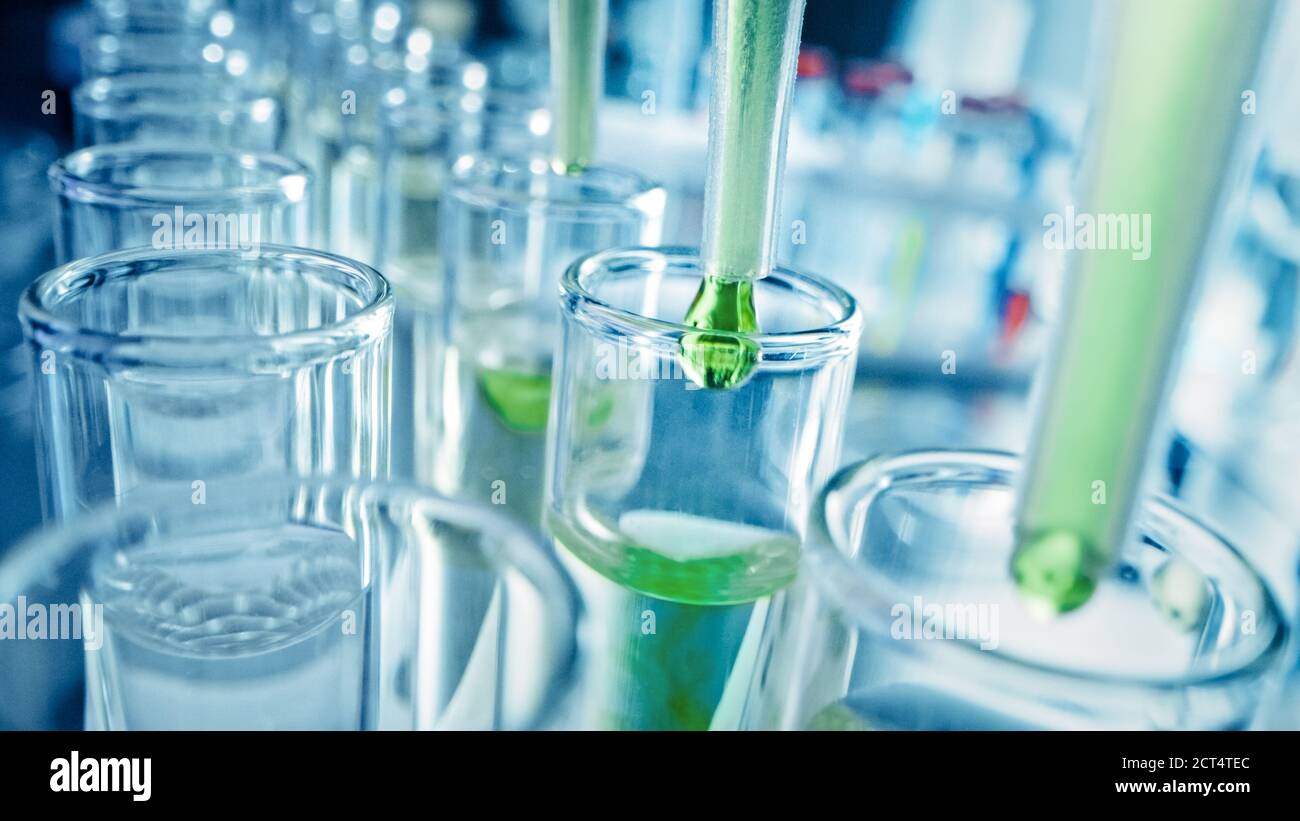 Pharmaceutics Laboratory: Multiple Pipettes Dropping Yellow Liquid into ...