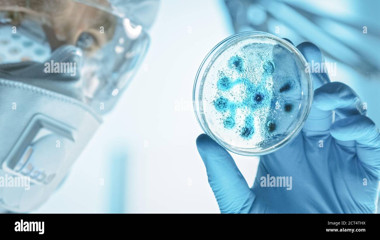 Scientist Wearing Respirator Mask, Coverall and Safety Glasses Looks at ...