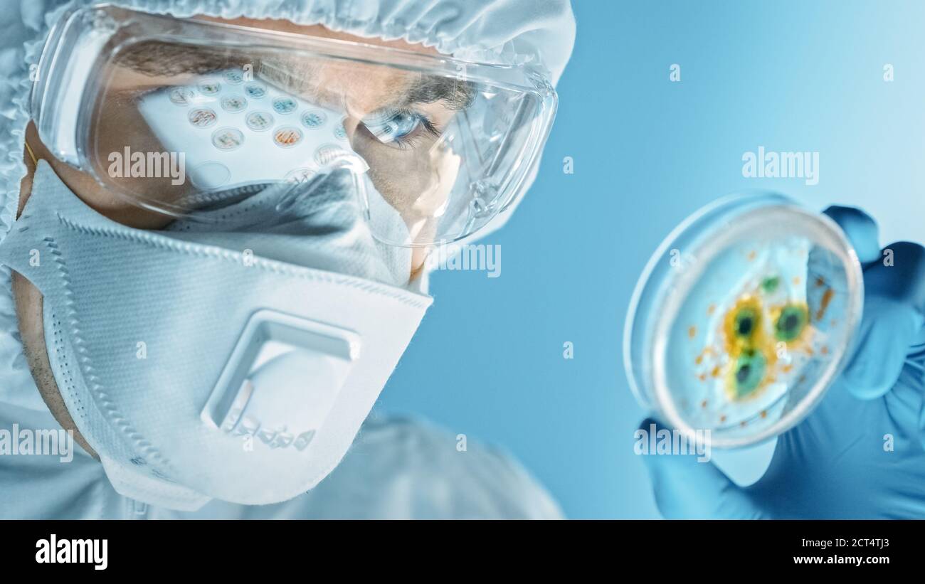 Scientist Wearing Respirator Mask, Coverall and Safety Glasses Looks at ...