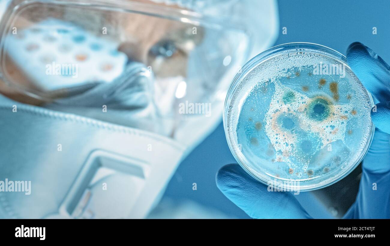 Scientist Wearing Respirator Mask, Coverall and Safety Glasses Looks at ...
