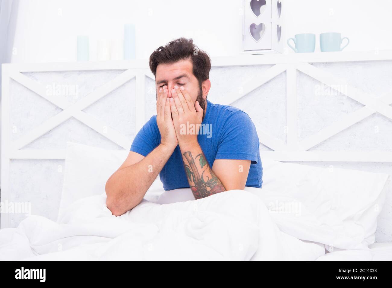 hate waking up. sleepy guy relax in bedroom. early morning. getting the ...