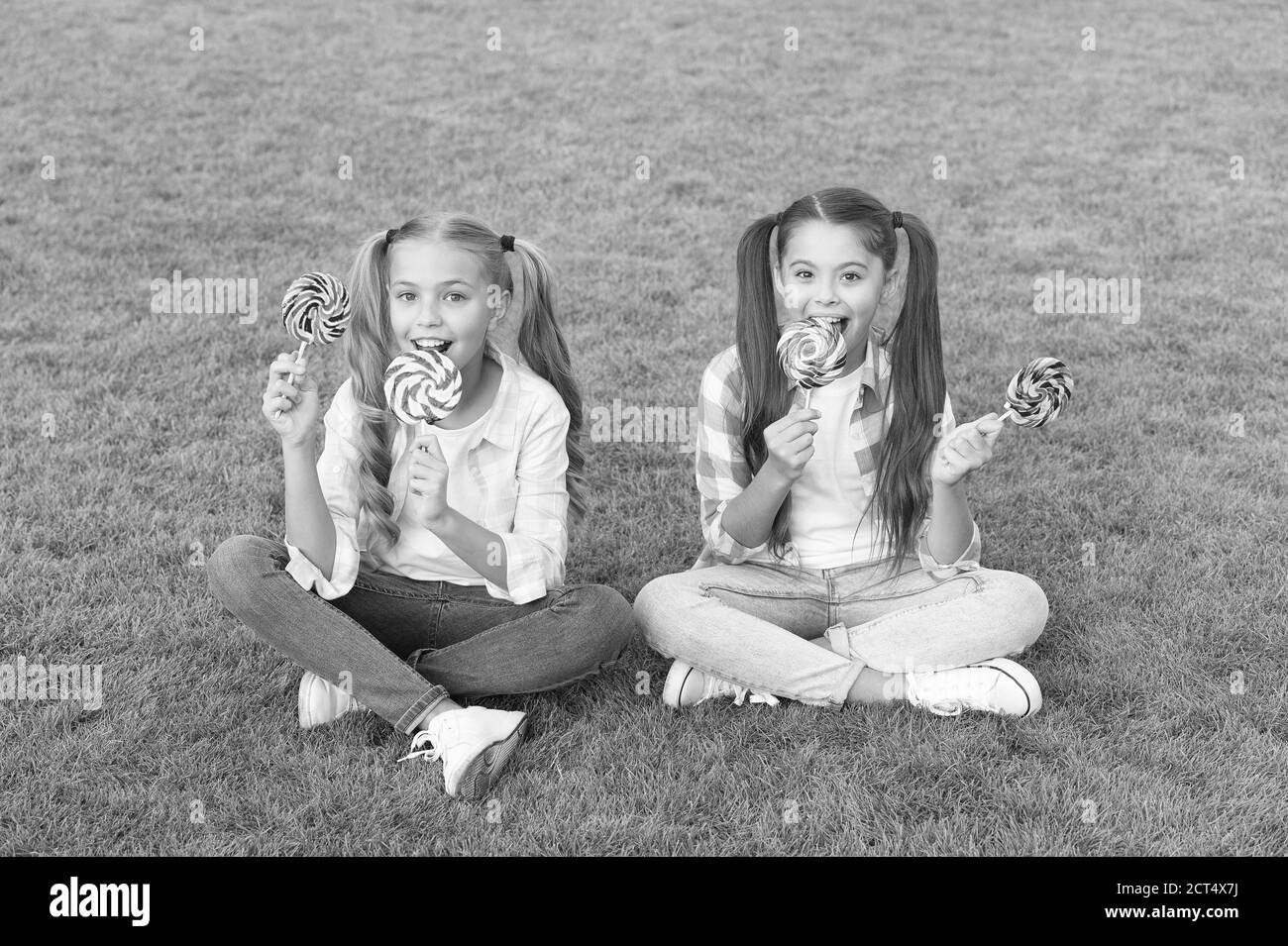Sweet caramel. Happy children hold candy sit grass. Candy shop ...