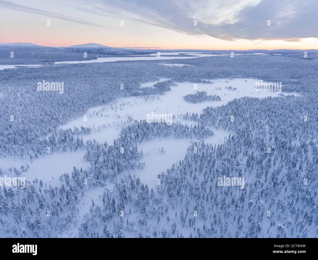 Aerial of remote snow covered lake and forest winter landscape showing ...