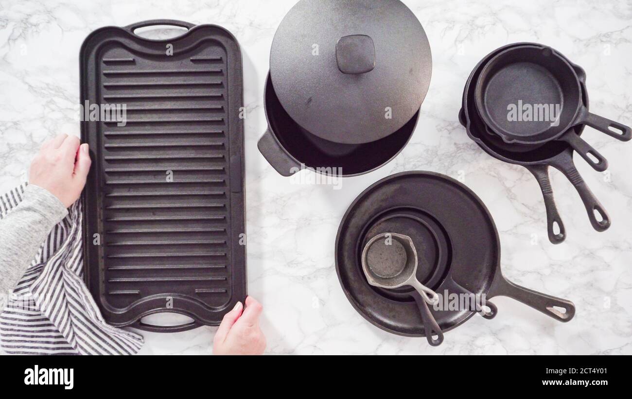 Flat lay. Variety of cast iron kitchenware on a marble countertop Stock ...