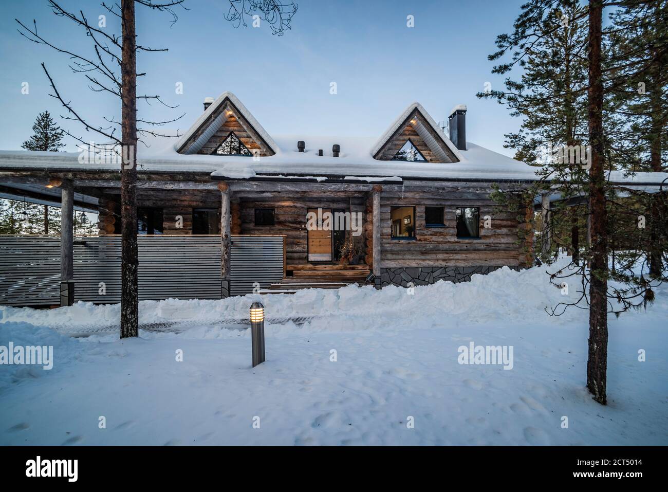 Wooden cabin in the remote forest, with snow covered woods and trees ...