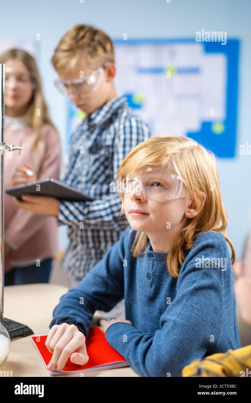 Portrait of a Cute Little Boy Wearing Safety Glasses, Sitting at his ...