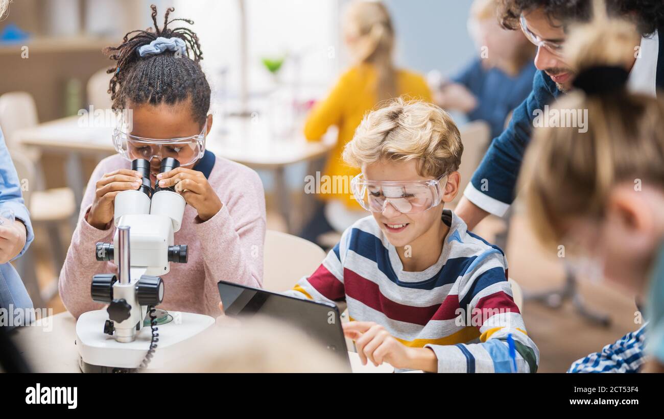 Elementary School Science Classroom: Cute Little Girl Looks Under ...