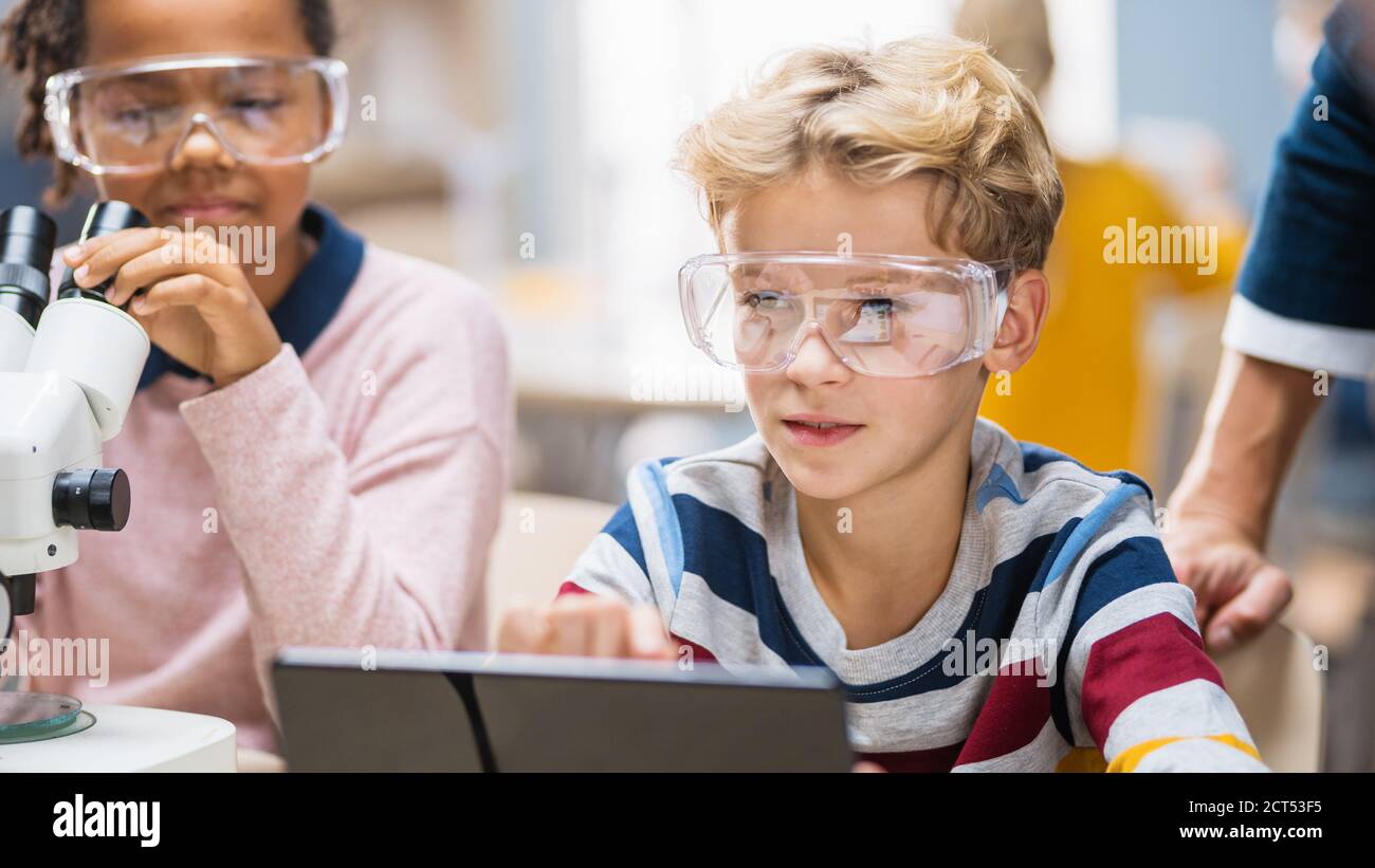 Elementary School Science Classroom: Boy Uses Digital Tablet Computer ...