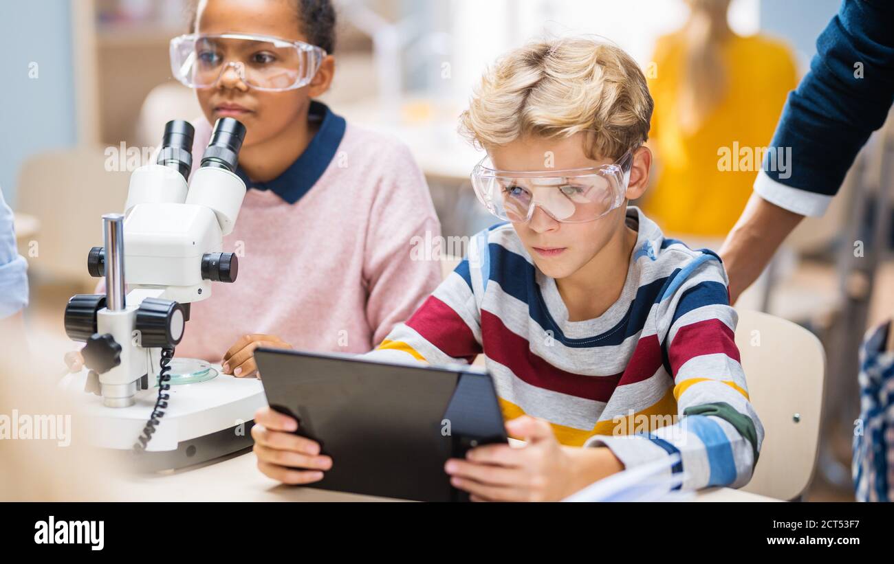 Elementary School Science Classroom: Boy Uses Digital Tablet Computer ...