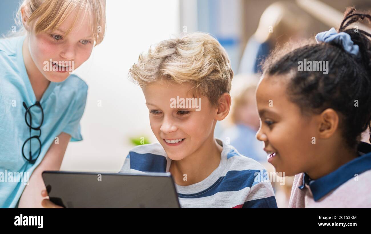Elementary School Computer Science Class: Two Girls and Boy Use Digital ...