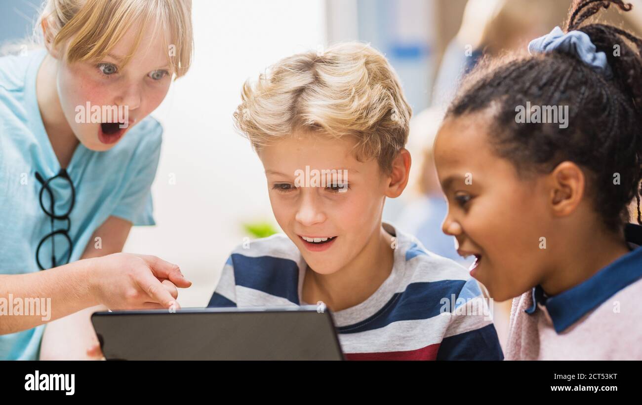 Elementary School Computer Science Class: Two Girls and Boy Use Digital ...