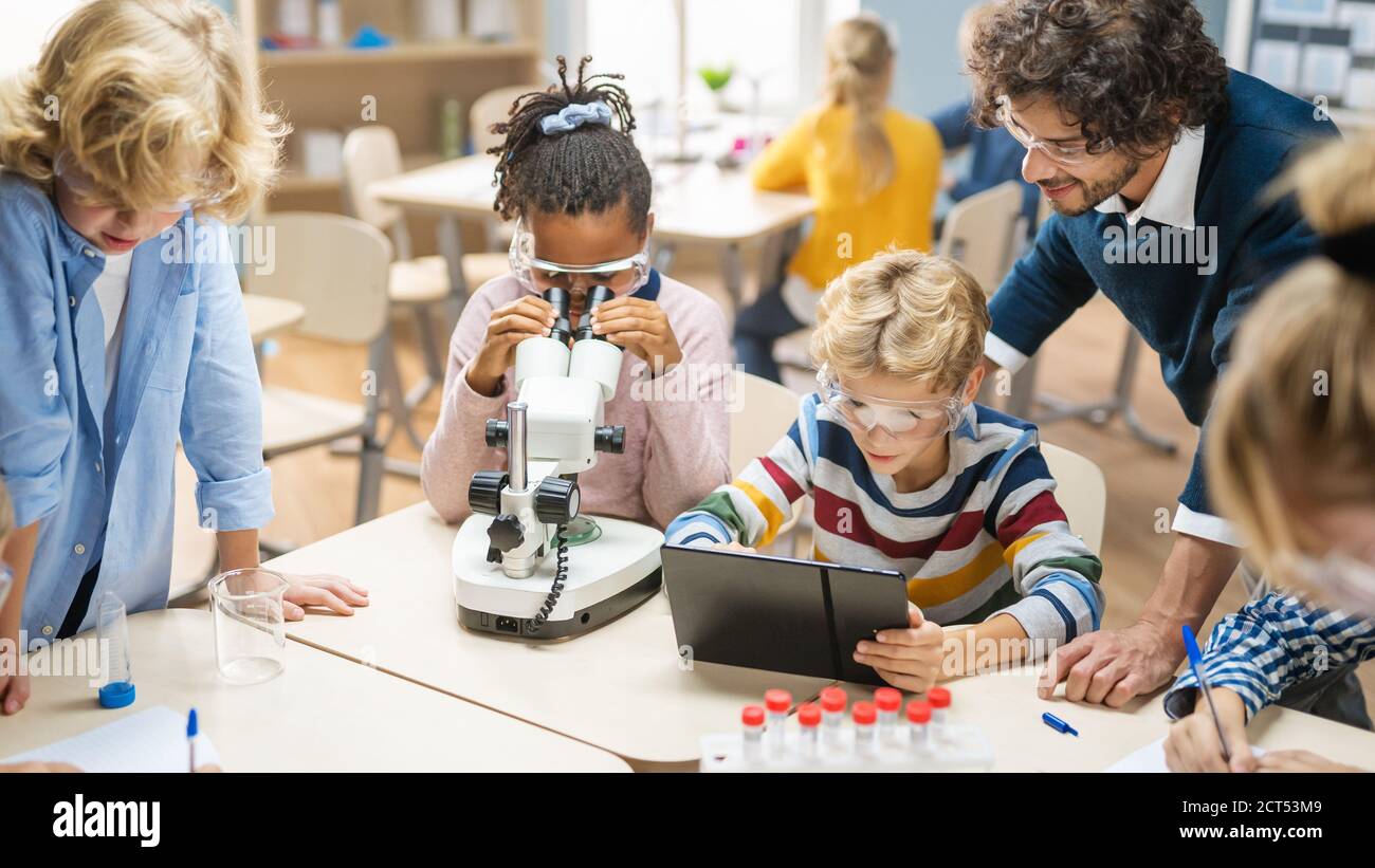 Elementary School Science Classroom: Cute Little Girl Looks Under ...