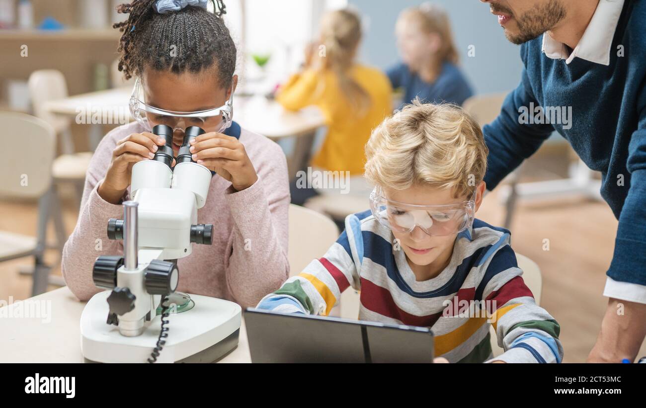 Elementary School Science Classroom: Cute Little Girl Looks Under ...
