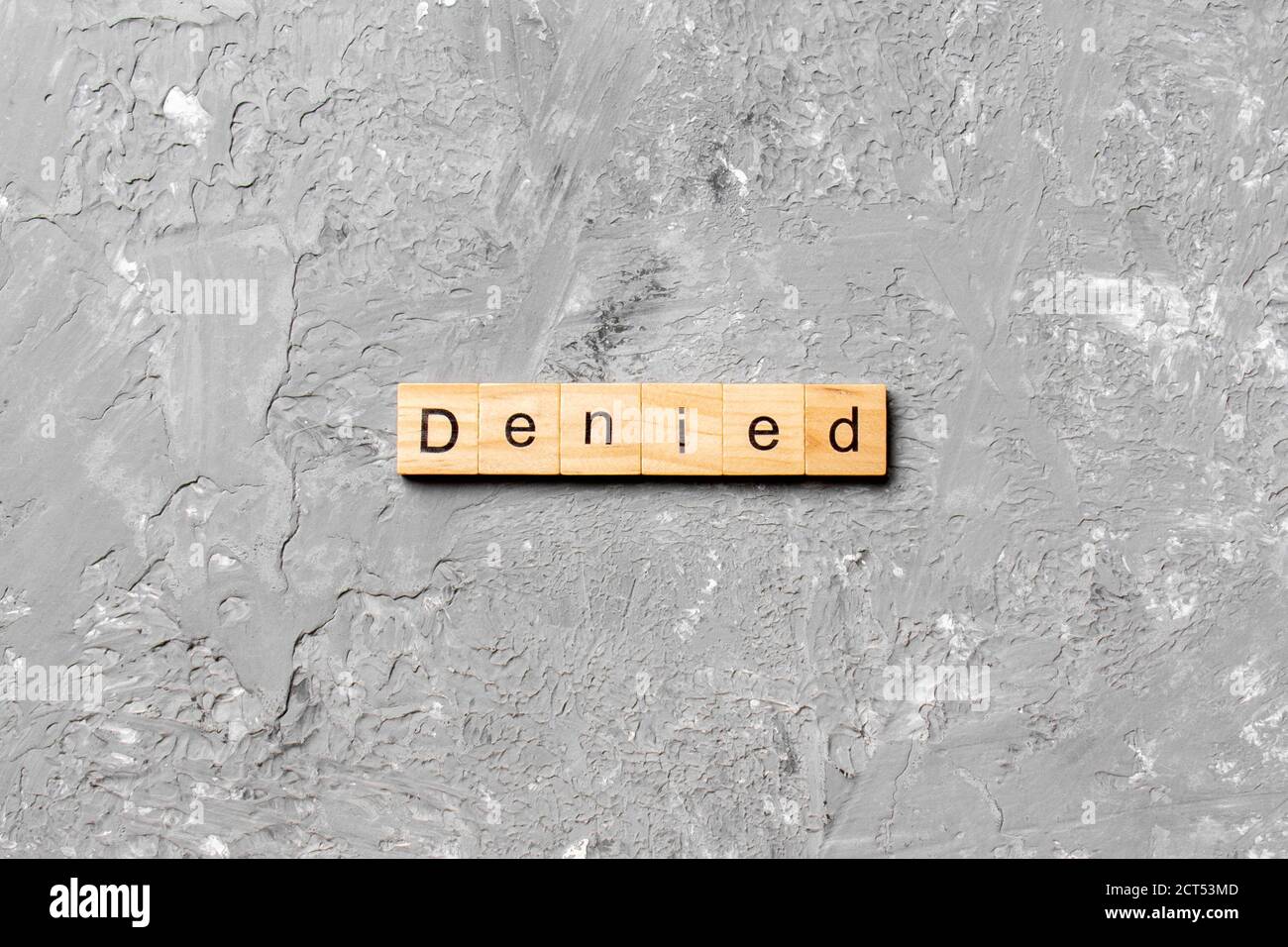 DENIED word written on wood block. DENIED text on cement table for your ...