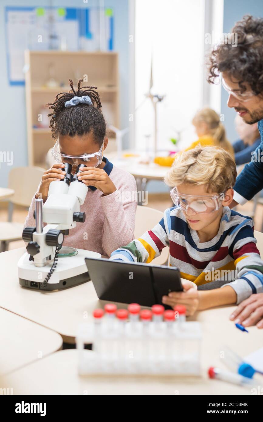 Elementary School Science Classroom: Cute Little Girl Looks Under ...