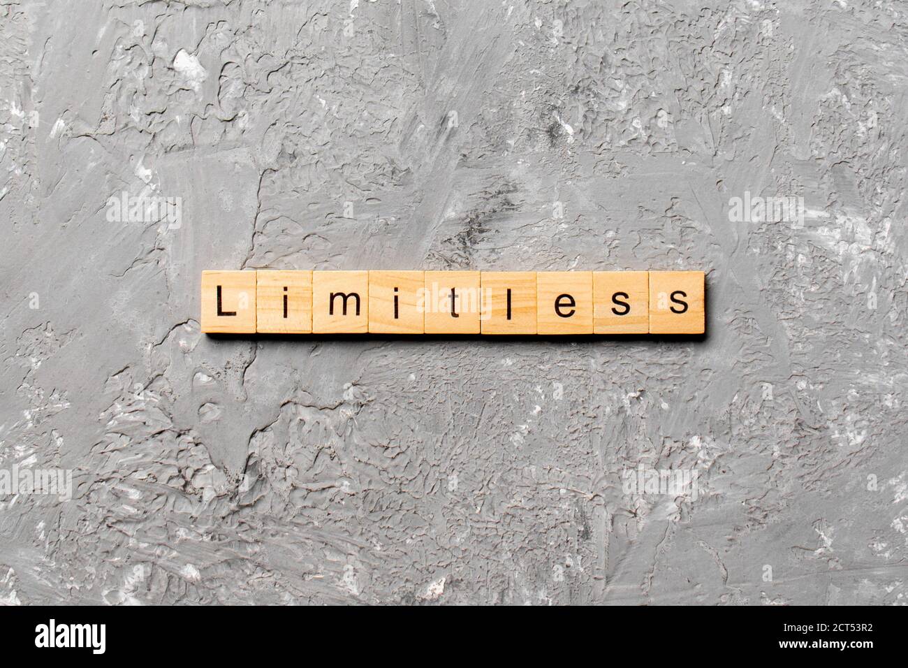 Limitless word written on wood block. Limitless text on cement table ...