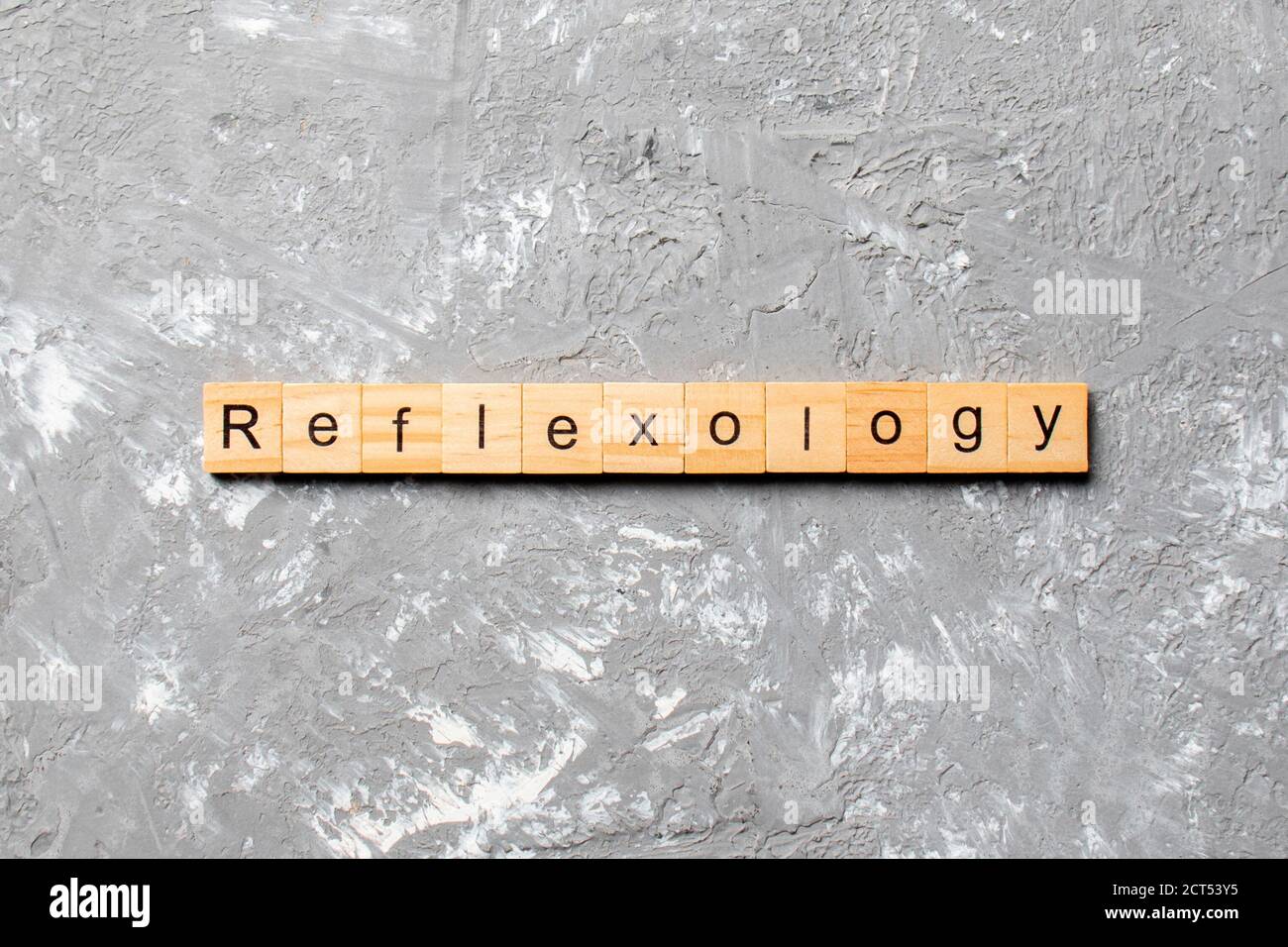 reflexology word written on wood block. reflexology text on cement ...