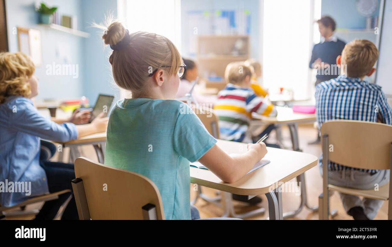 Elementary School Science Class: Cute Little Girl is Listening to a ...