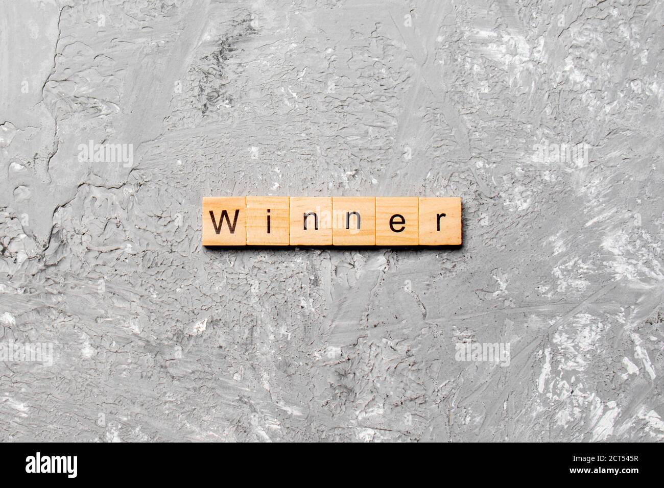 WINNER word written on wood block. WINNER text on cement table for your ...