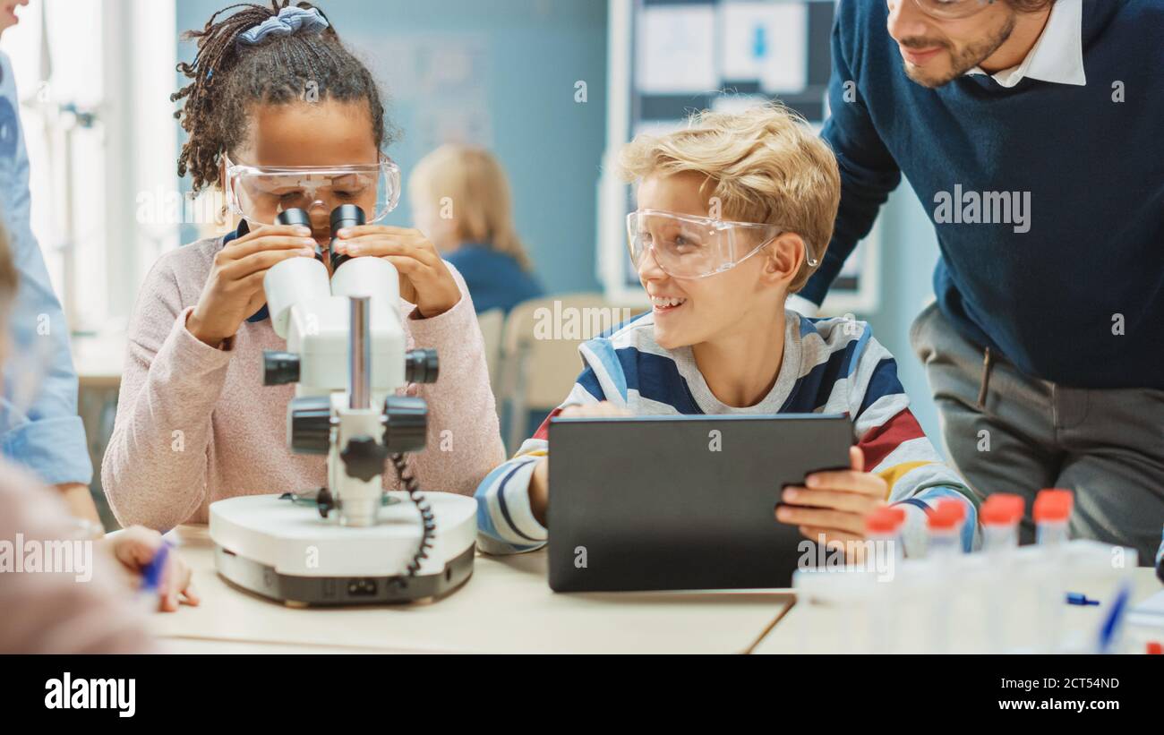 Elementary School Science Classroom: Cute Little Girl Looks Under ...
