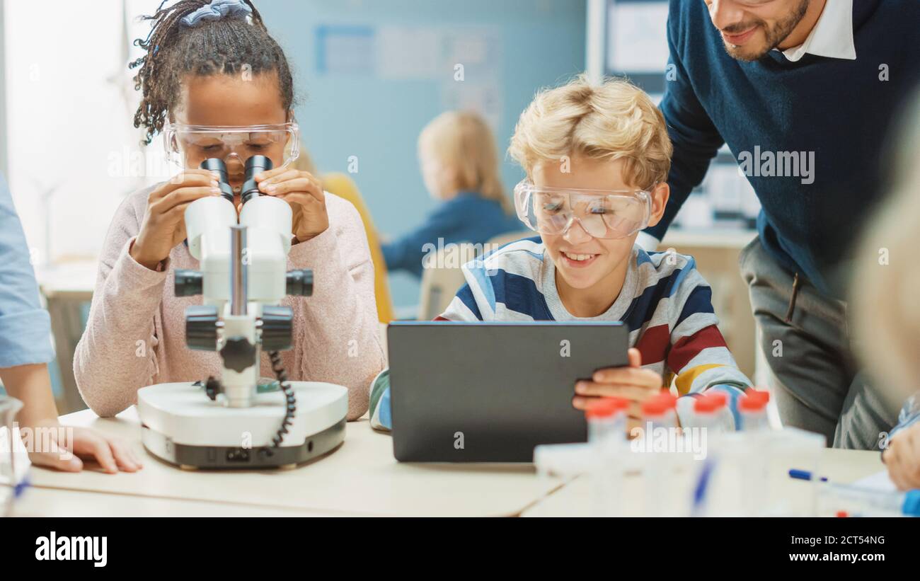Elementary School Science Classroom: Cute Little Girl Looks Under ...