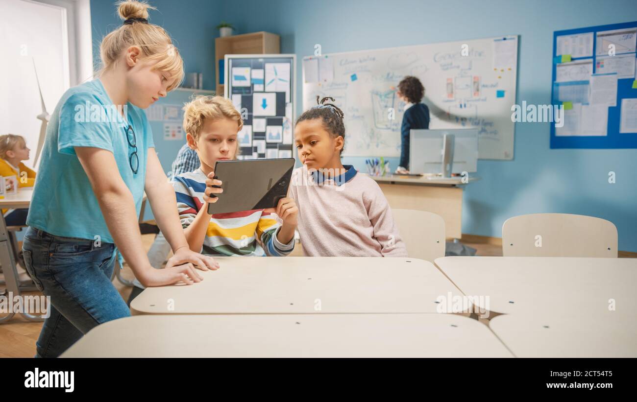 Elementary School Computer Science Class: Two Girls and Boy Use Digital ...