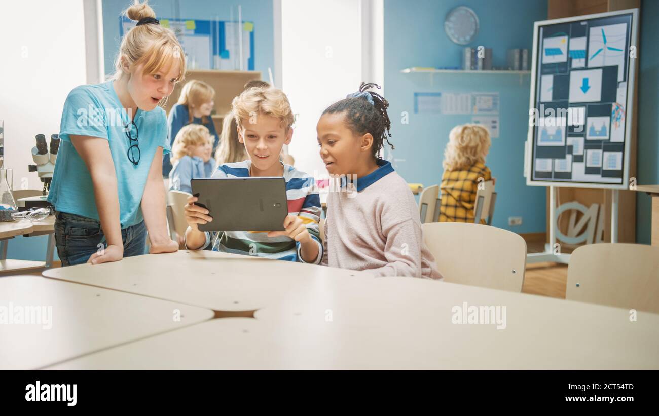Elementary School Computer Science Class: Two Girls and Boy Use Digital ...