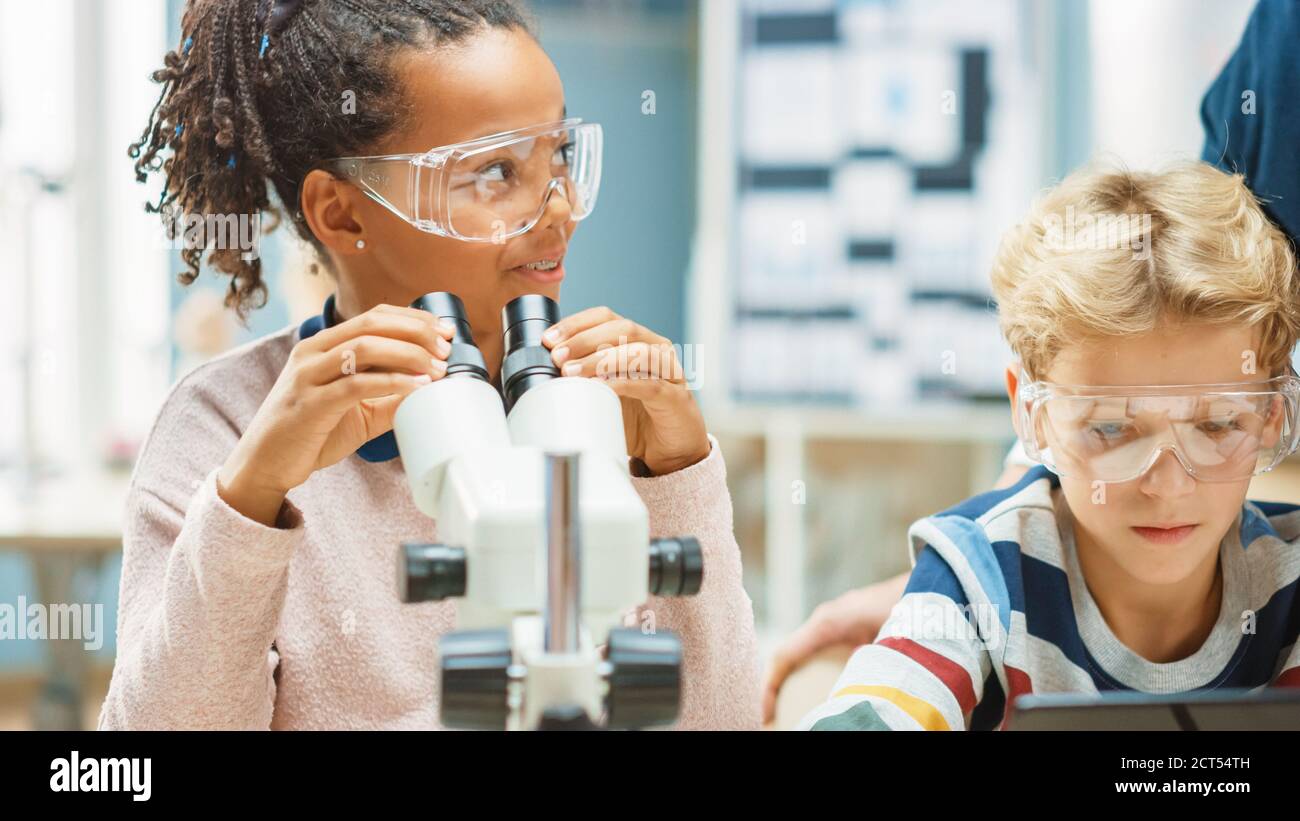Elementary School Science Classroom: Cute Little Girl Looks Under ...