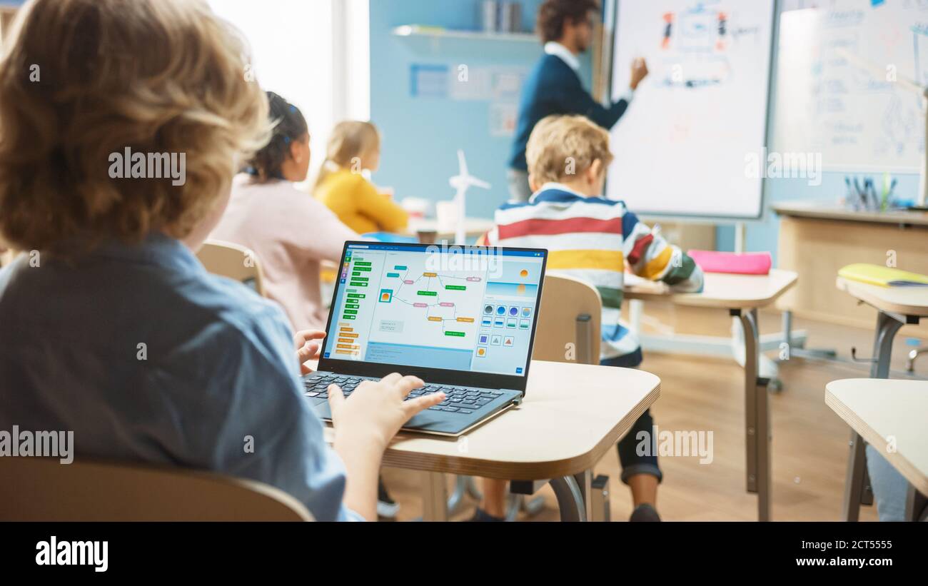 Elementary School Science Class: Over the Shoulder Little Boy Uses ...